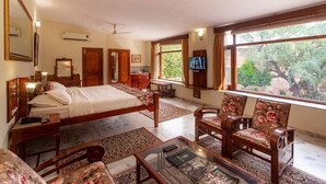 Quarto com uma cama, televisão, escrivaninha e cadeira.