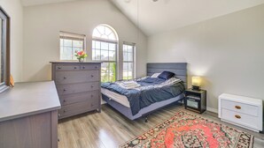 Quarto com cama, cômoda, mesa de cabeceira e ventilador de teto.