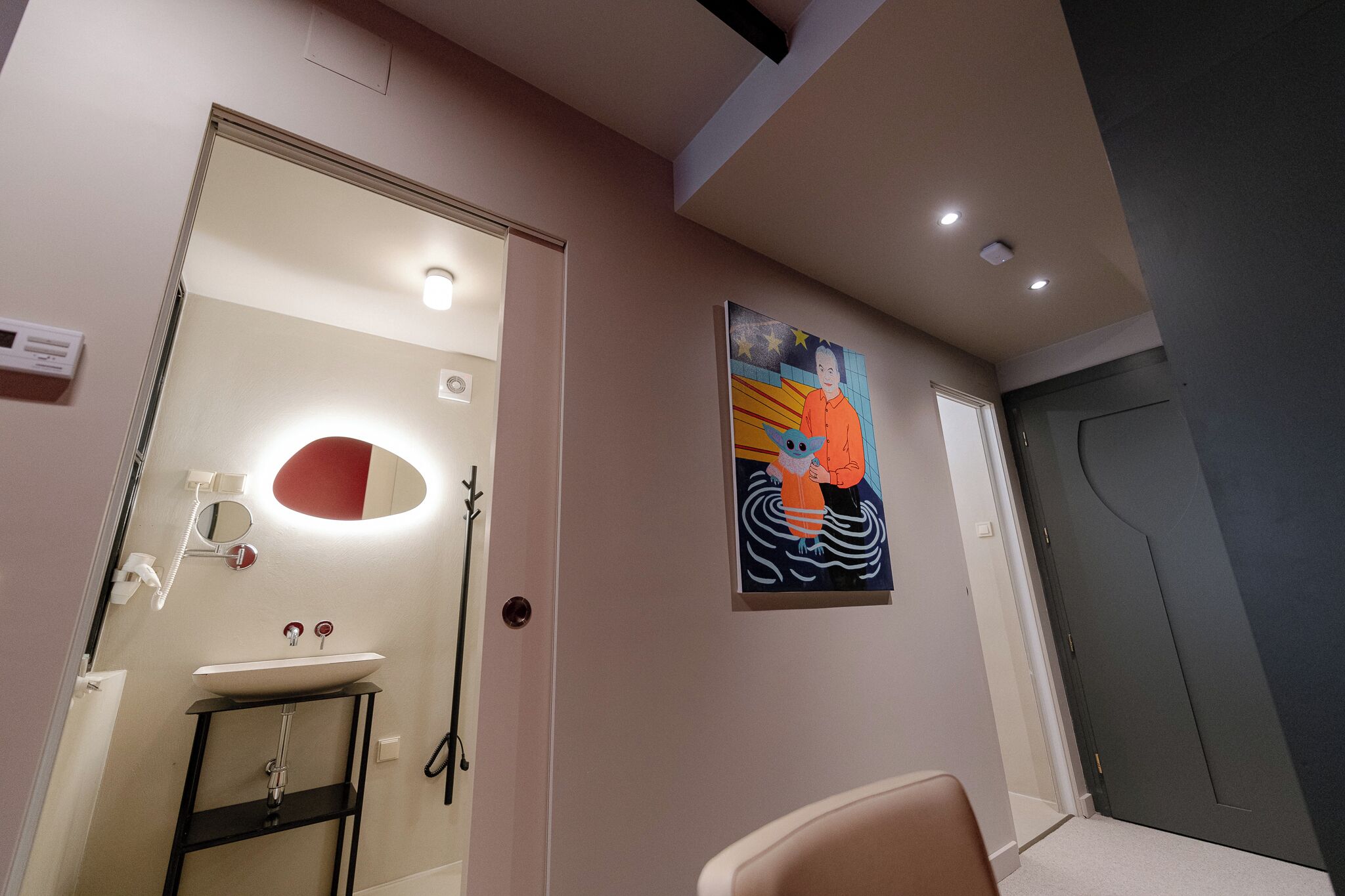 Casa de banho moderna com lavatório, espelho e porta-toalhas.
