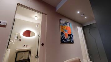 Casa de banho moderna com lavatório, espelho e porta-toalhas.