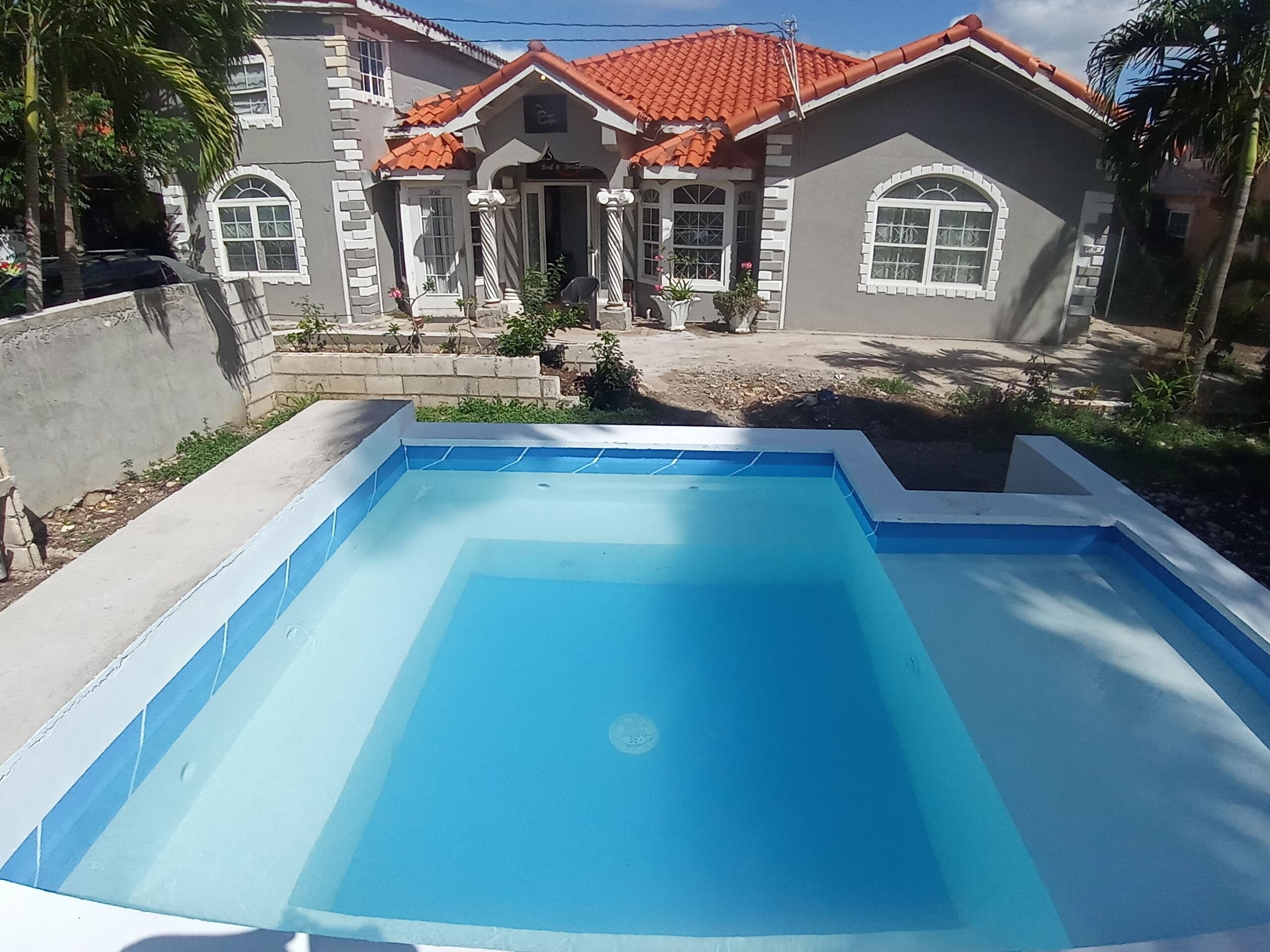 Piscina com interior azul, rodeada por um deck de concreto.