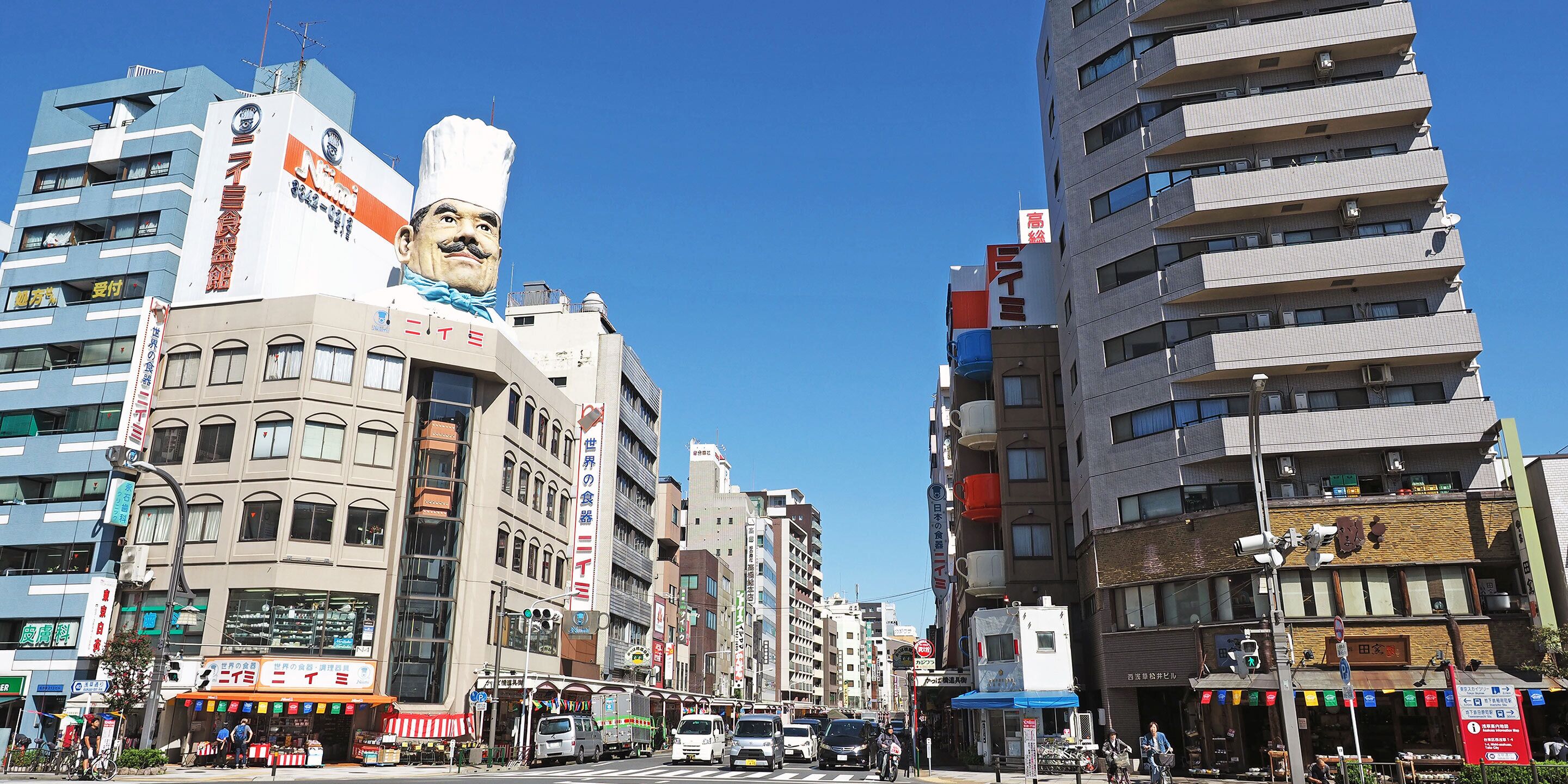 Um edifício de vários andares com estabelecimentos comerciais no andar térreo, incluindo uma farmácia e uma loja de conveniência.