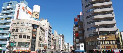 Um edifício de vários andares com estabelecimentos comerciais no andar térreo, incluindo uma farmácia e uma loja de conveniência.