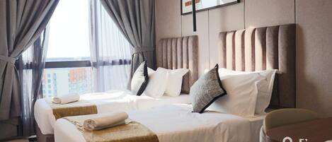Quarto de hotel com duas camas, uma janela grande com cortinas, cabeceira com linhas verticais e um quadro na parede.