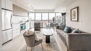 Cozinha moderna com área de refeições, sofá e vista para a cidade.