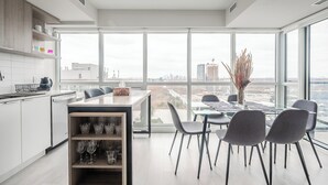 Cozinha moderna com área de refeições, janelas amplas e vista para a cidade.