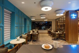 Um restaurante moderno com paredes azuis, móveis de madeira e chão estampado.