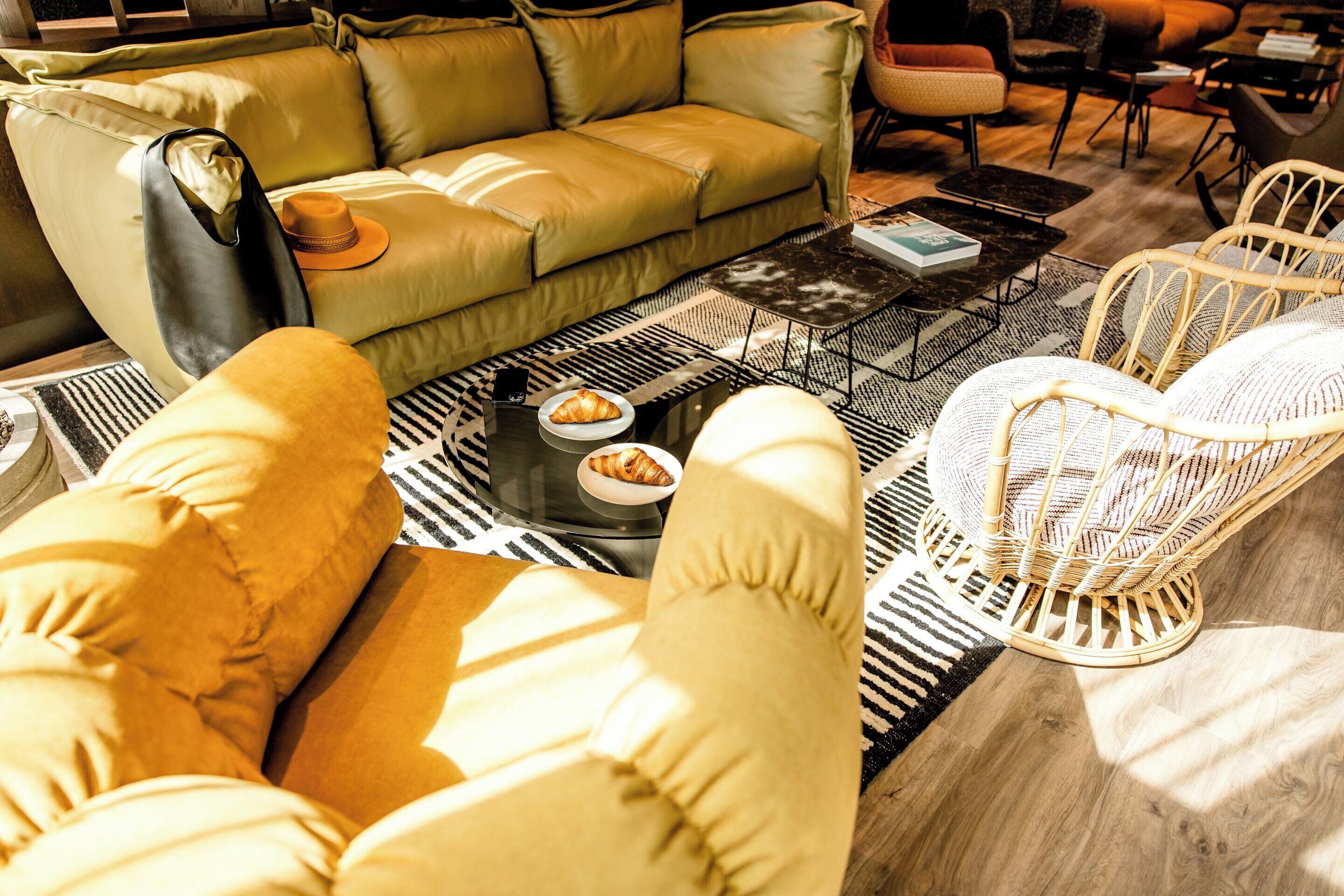 Uma área de estar acolhedora com um sofá, poltronas e uma mesa de centro.