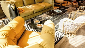 Uma área de estar acolhedora com um sofá, poltronas e uma mesa de centro.
