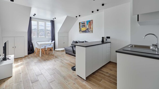 Um apartamento moderno com cozinha, sala de jantar e área de estar.