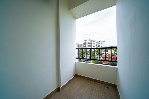 Uma varanda com vista para edifícios e guarda-corrimão de metal.