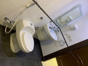 Casa de banho moderna com sanita, bidé e lavatório.