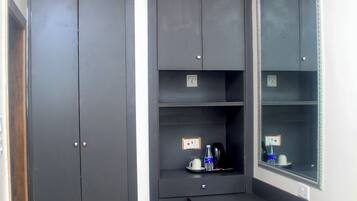 Quarto com escrivaninha, cadeira, guarda-roupa e espelho.