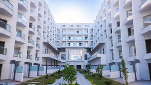 Um edifício residencial moderno, com vários andares e um pátio central.