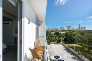 Varanda com vista para edifícios altos e áreas verdes.