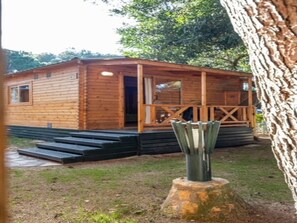 Uma cabana de madeira com varanda e degraus que levam à entrada.