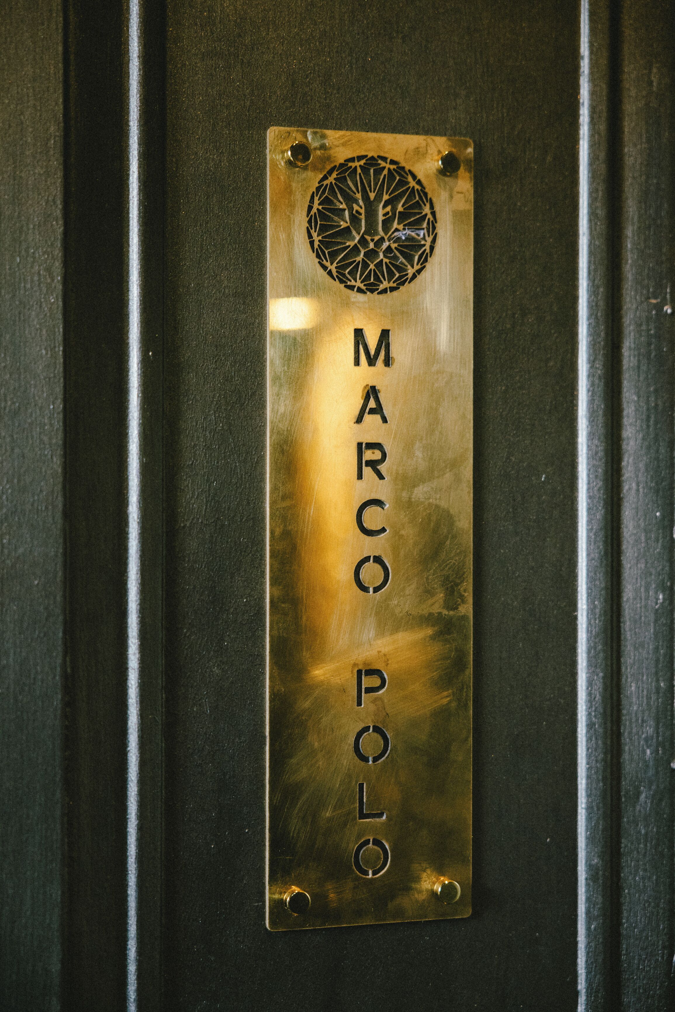 Uma placa de latão com o nome 'MARCO POLO' gravado.