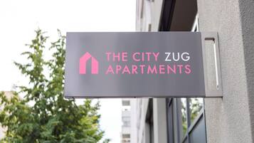 Placa para "The City Zug Apartments" com um ícone de casa.