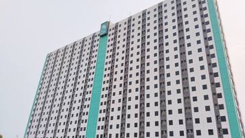 Um edifício alto com grade de janelas e sacadas.