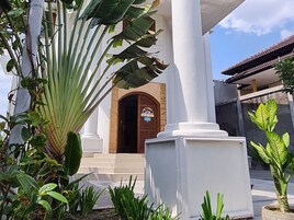 Um edifício com uma entrada imponente, colunas brancas e uma placa sobre a porta.