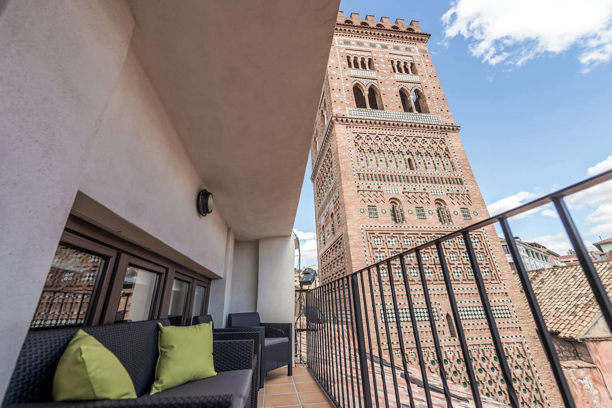 Uma varanda com vista para uma torre alta e ricamente decorada.