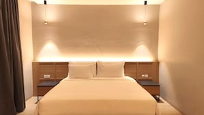 Quarto moderno com uma cama grande, duas mesas de cabeceira e um lustre.