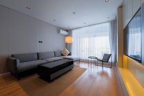 Uma sala de estar moderna com um sofá, mesa de centro e uma poltrona.
