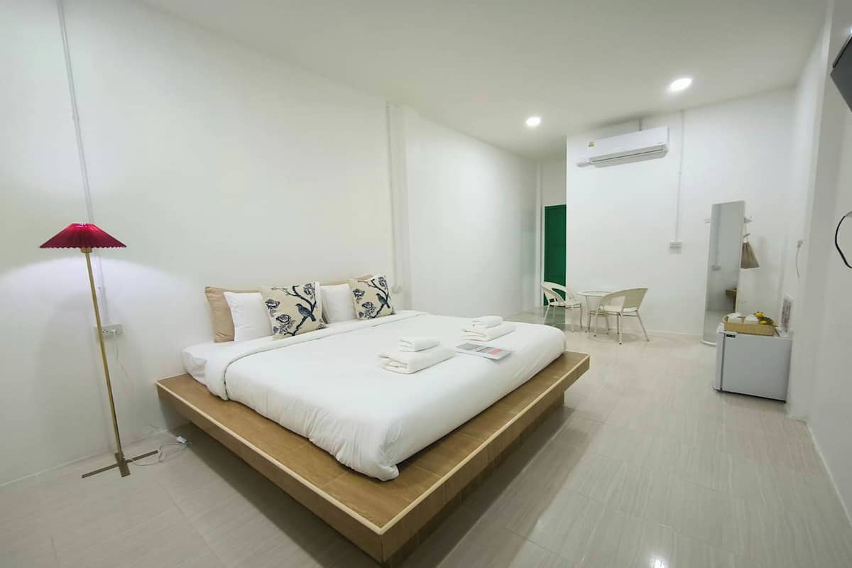 Quarto de hotel moderno com uma cama grande, uma escrivaninha e uma cadeira.