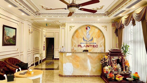 Um saguão com balcão de recepção, escada e um santuário decorativo.