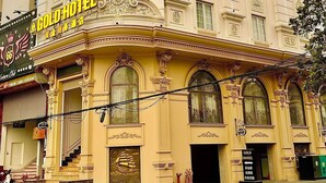 Um edifício histórico com detalhes arquitetônicos elaborados, incluindo janelas em arco e molduras decorativas.