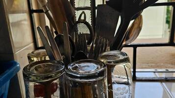 Um suporte para utensílios de cozinha com diversos utensílios e potes de vidro.