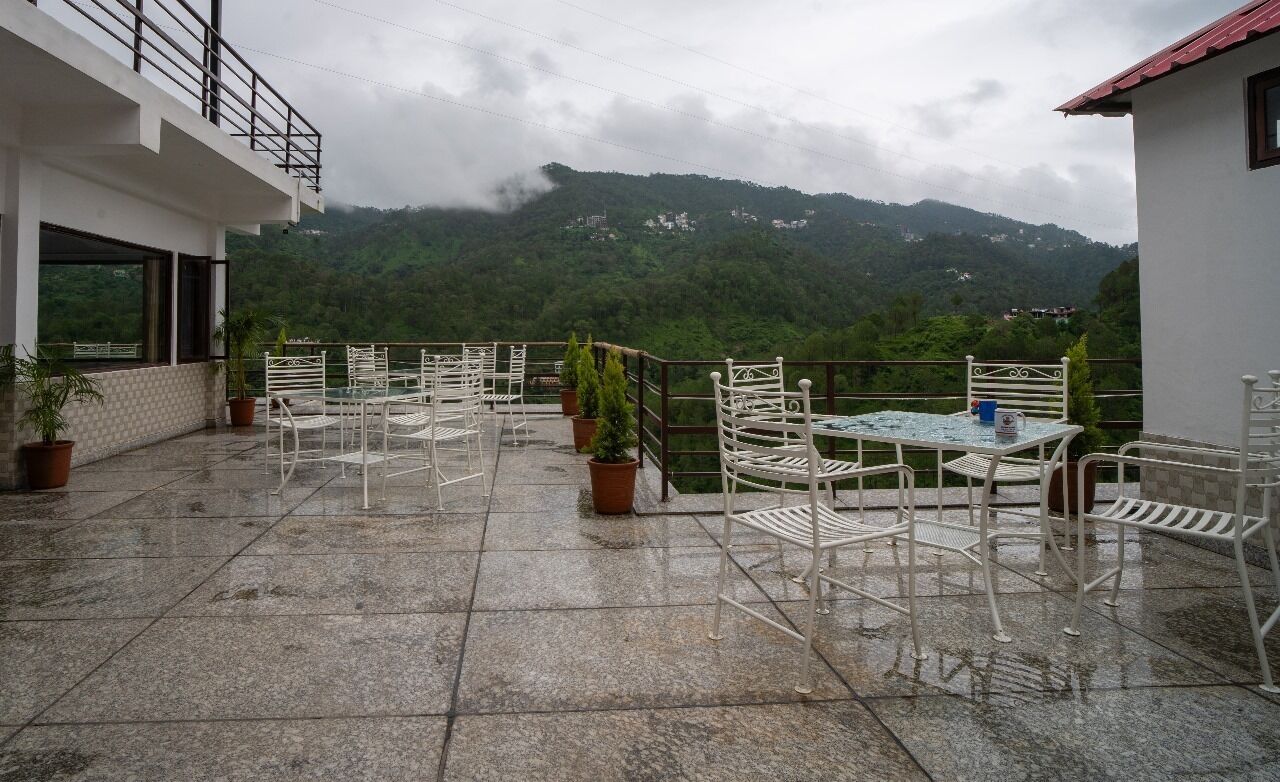 Terraço com área de estar ao ar livre e vista para uma paisagem montanhosa.