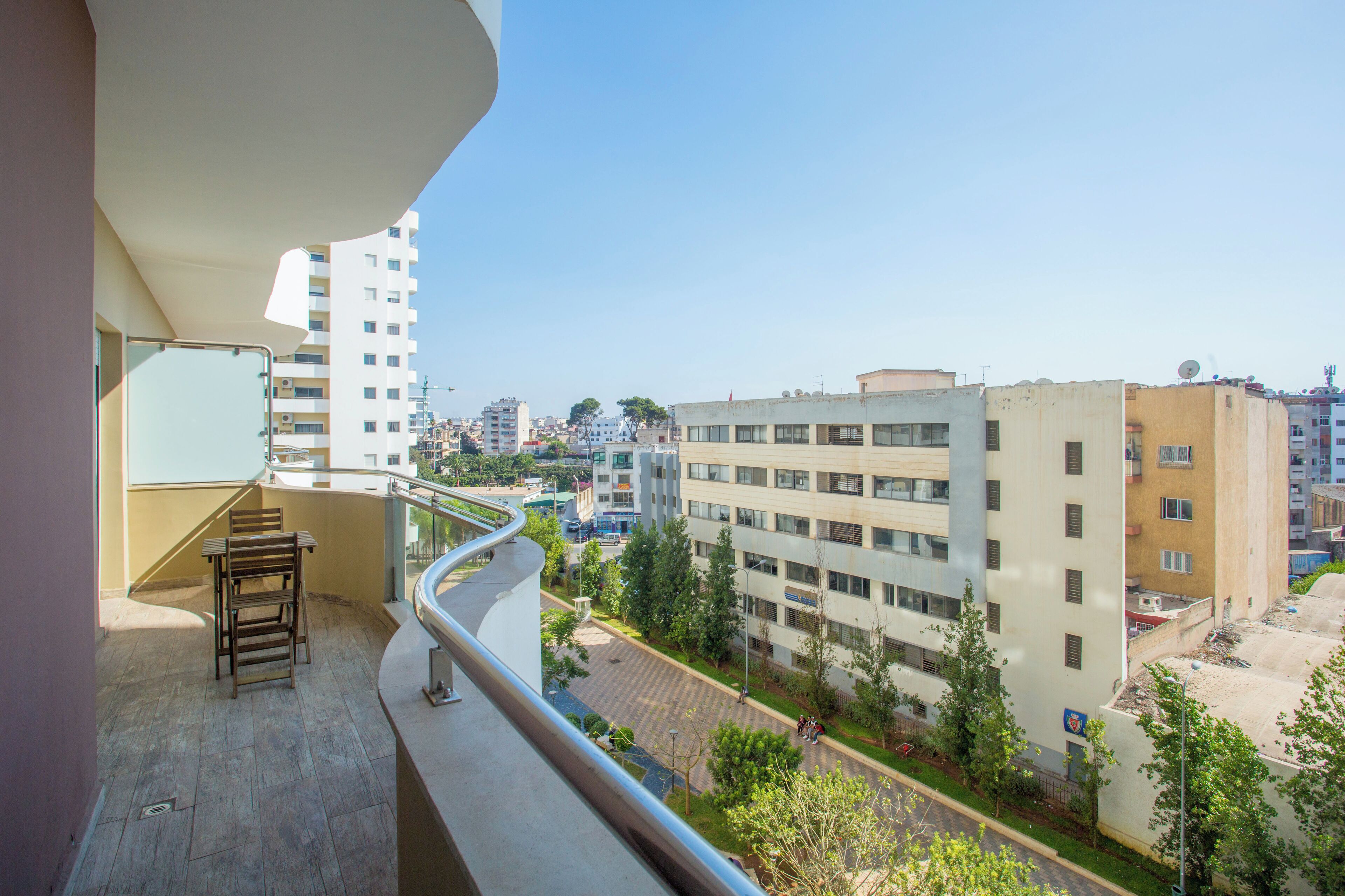 Uma varanda com vista para um horizonte urbano, incluindo edifícios e uma estrada.