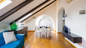 Um loft moderno com área de refeições, vigas de madeira e claraboia.