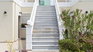 Um edifício de dois andares com uma escadaria central que dá para uma varanda.