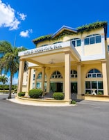 Um hotel com uma entrada ampla, colunas e área coberta.