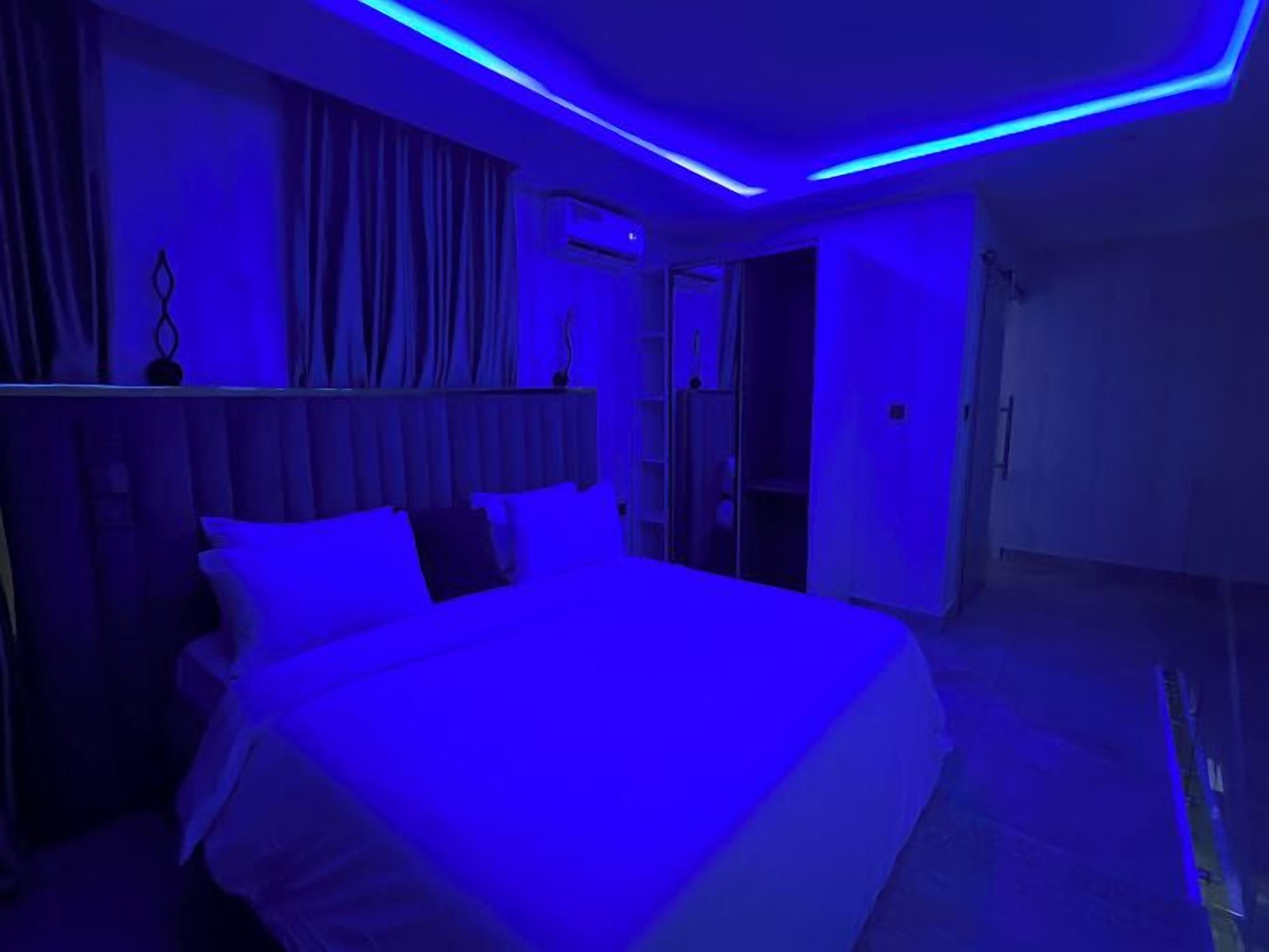 Quarto com cama, cortinas e ar condicionado.