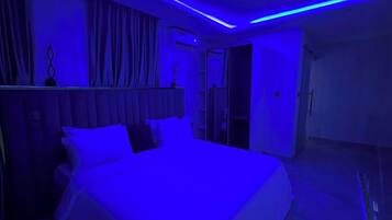 Quarto com cama, cortinas e ar condicionado.