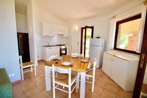 Apartamento, vista para o mar | Cozinha privada | Um frigorífico, um forno, utensílios de cozinha, mesas de jantar 