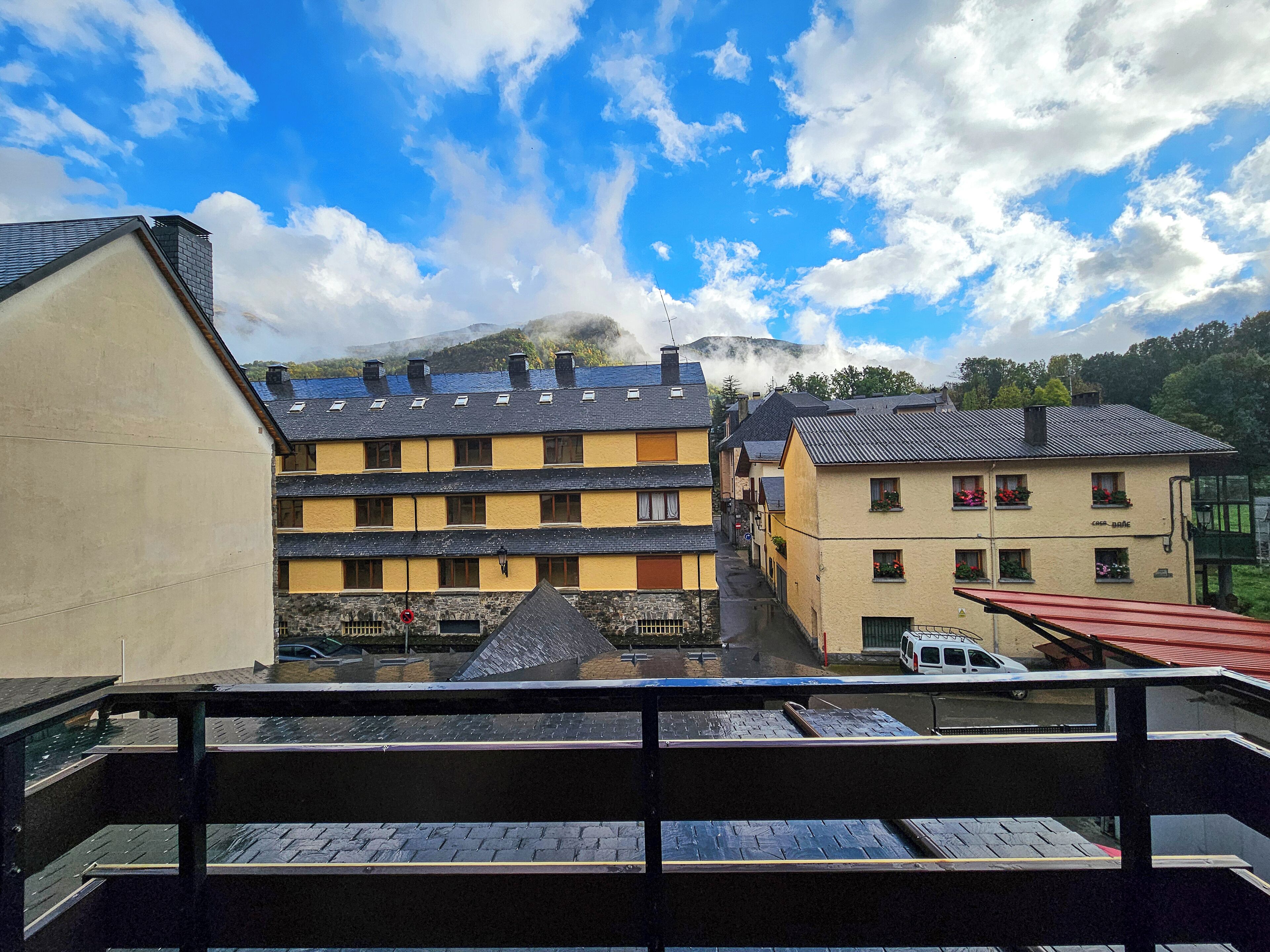 Vista de uma cidade com edifícios e uma montanha ao fundo.