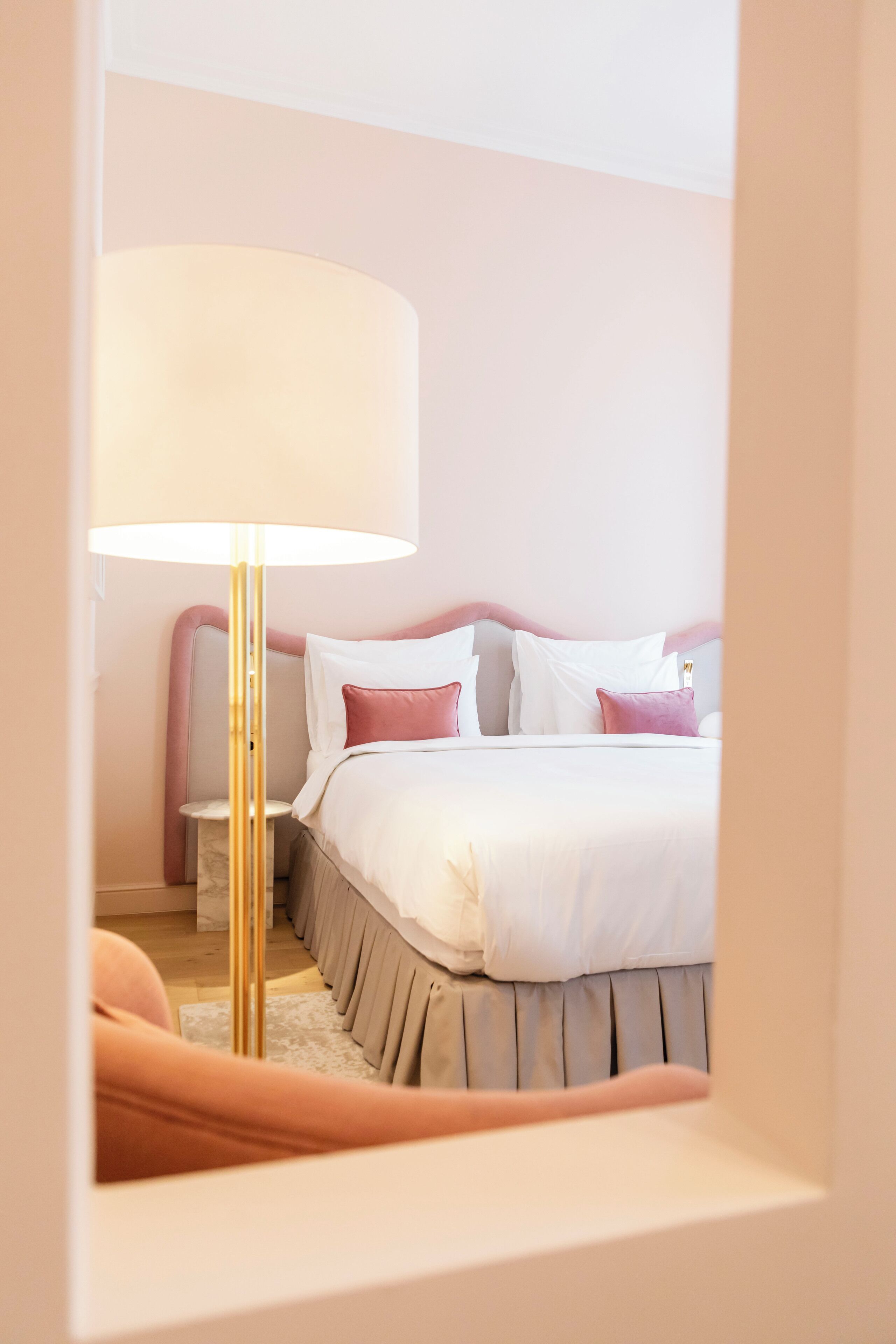 Quarto bem arrumado com cama, mesa de cabeceira e abajur.