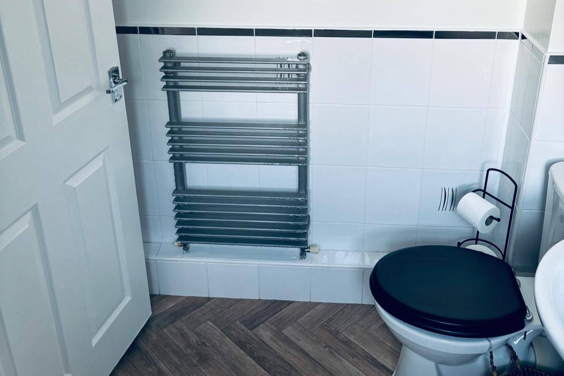Um banheiro com vaso sanitário, porta-toalhas e rolo de papel higiênico.