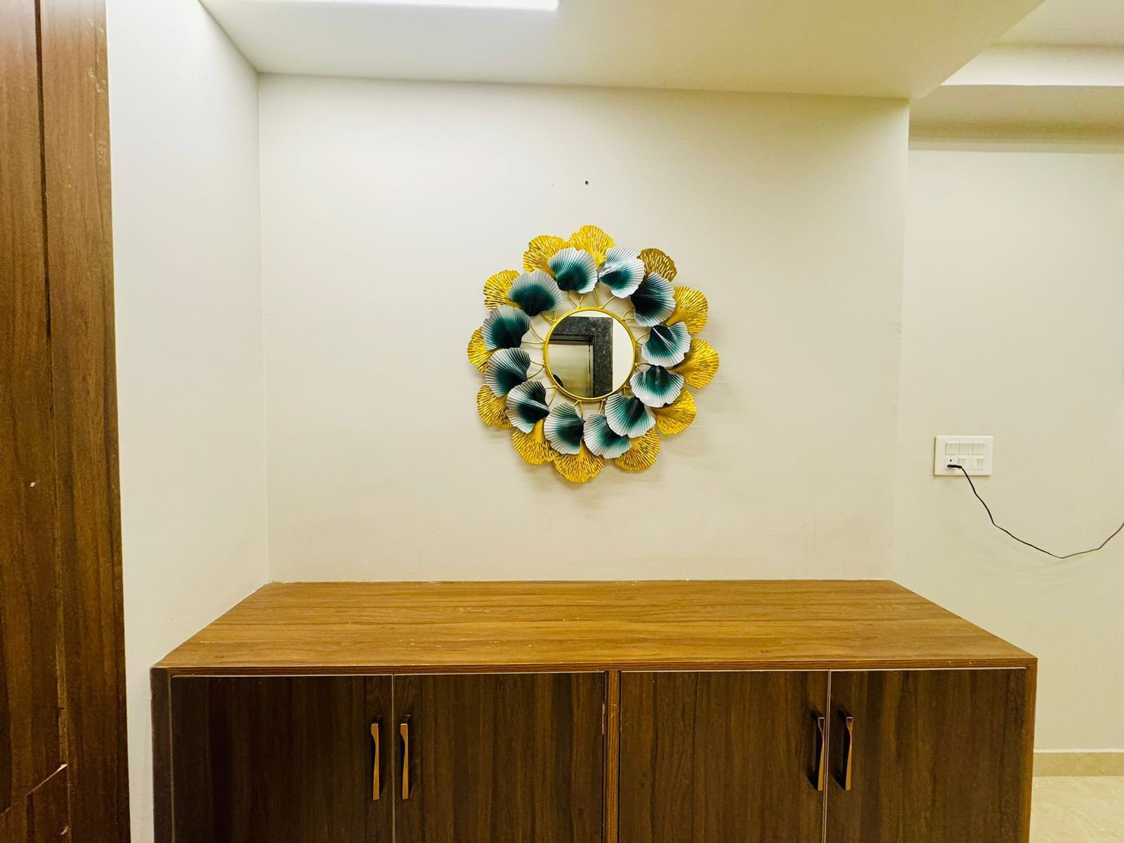 Quarto com armário de madeira, espelho fixado na parede e tomada.