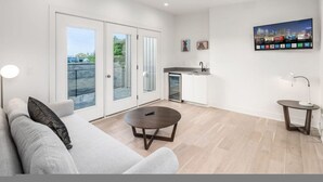 Um apartamento moderno com sala de estar, cozinha e varanda.
