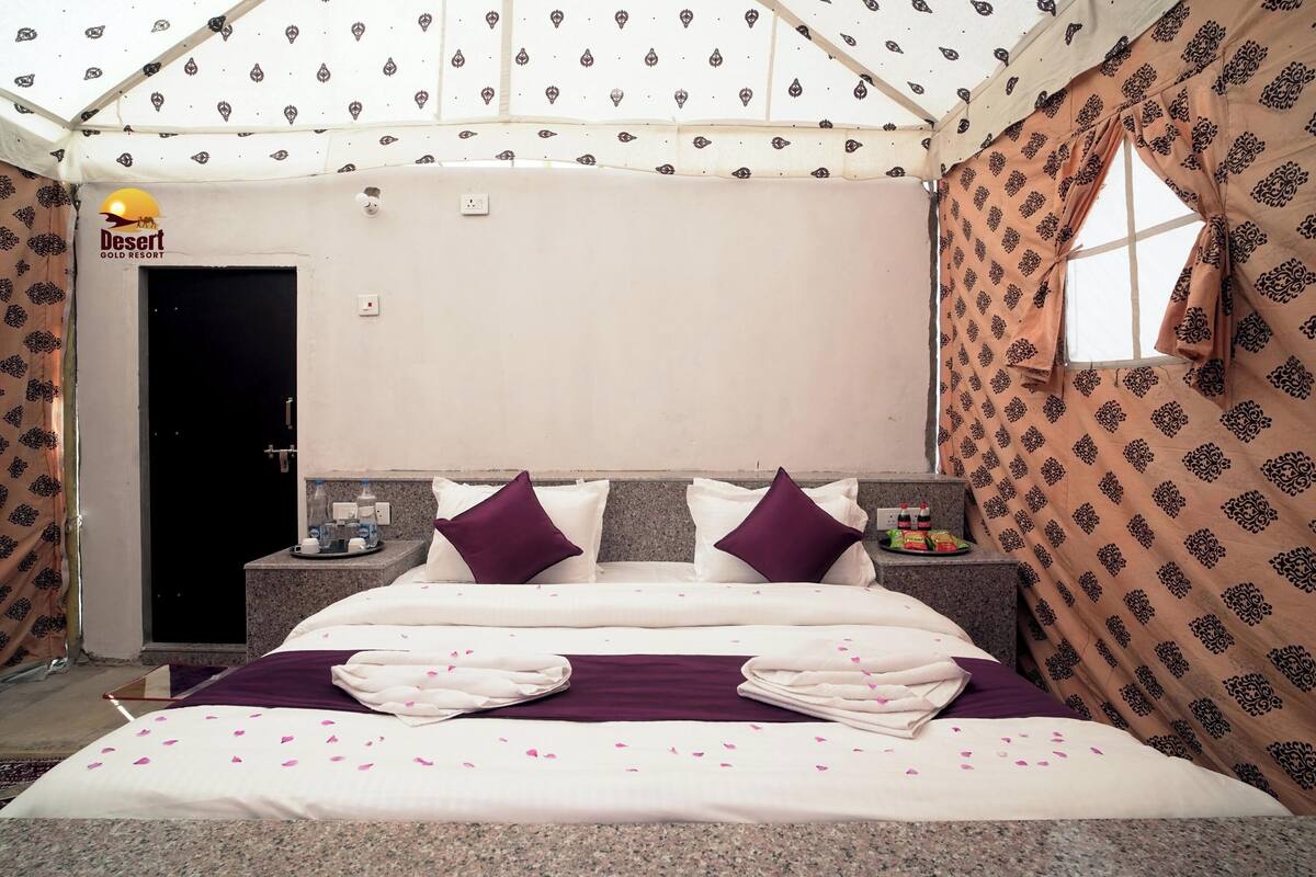 Quarto de hotel com cama, duas mesas de cabeceira, janela e porta.