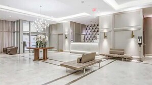 Um lobby moderno com balcão de recepção, área de estar e um candelabro.