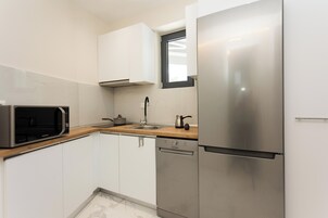 Apartamento superior, vista parcial para o mar | Cozinha americana privada | Frigobar, cooktop, talheres/pratos/utensílios de cozinha