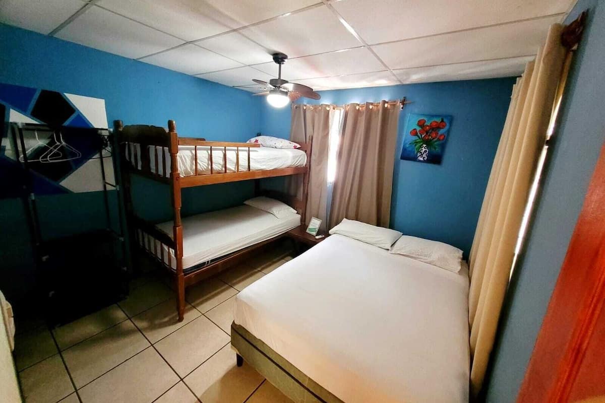 Um quarto com uma cama de solteiro, uma escrivaninha e uma cama.
