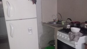 Uma cozinha compacta com geladeira branca, pia e fogão.