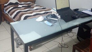 Um quarto com uma cama, uma escrivaninha com um laptop e uma cadeira.